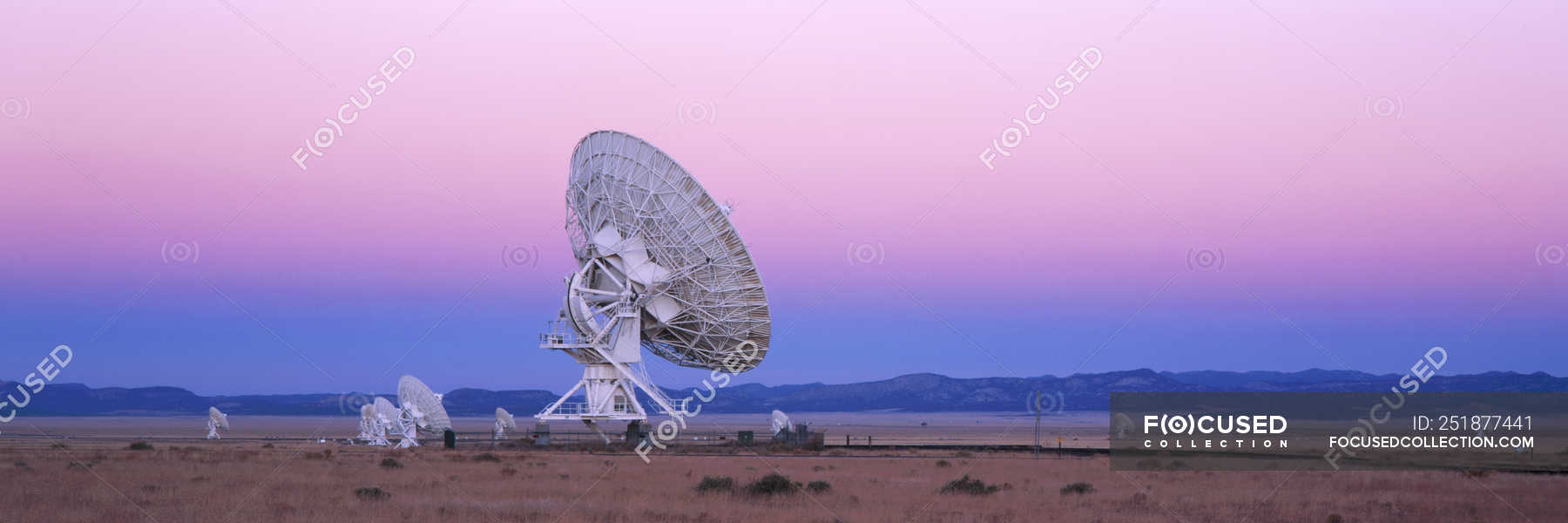 Large array radio telescope in valley under pink sky at sunset, New ...