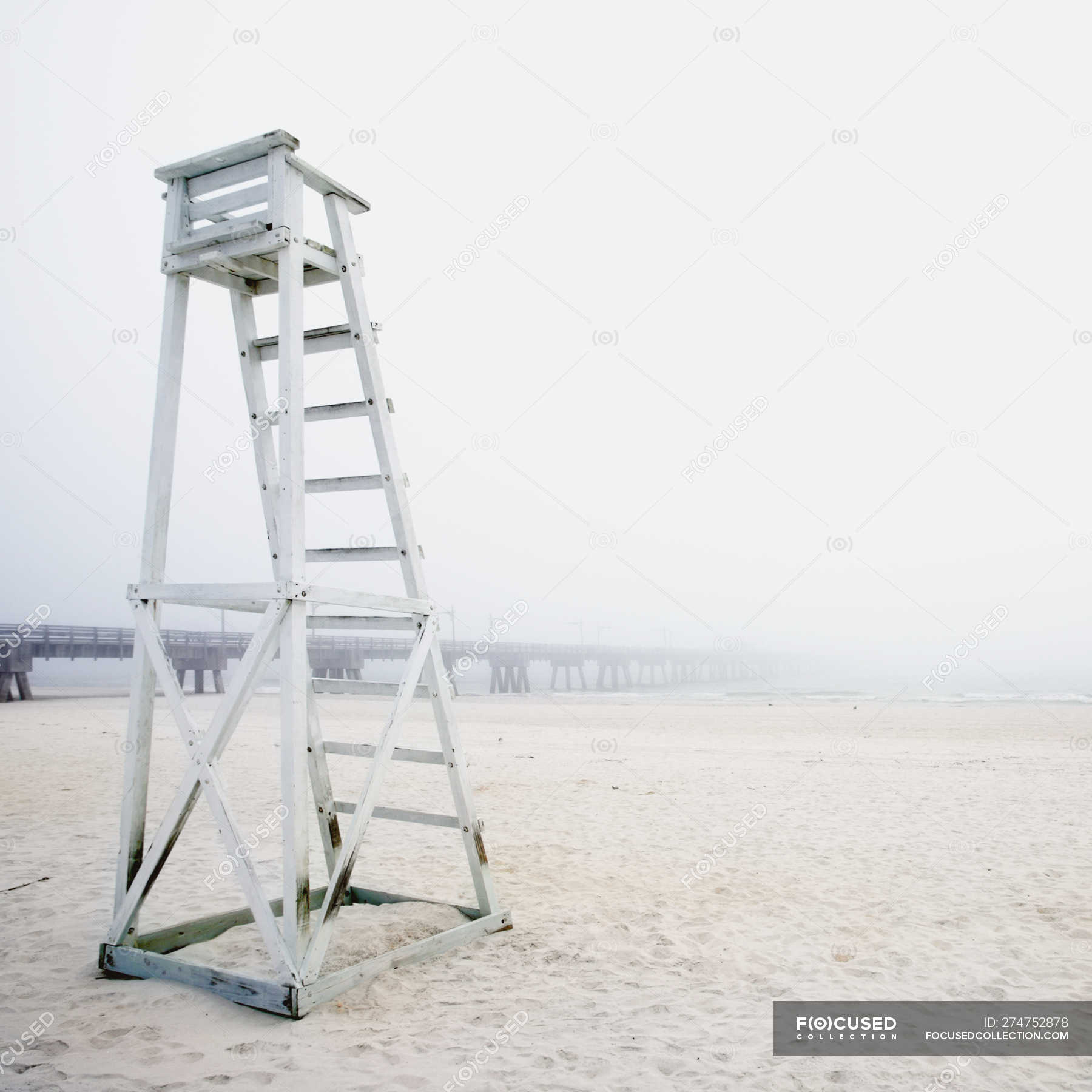 Empty lifeguard station and wooden pier in fog, Panama City Beach ...