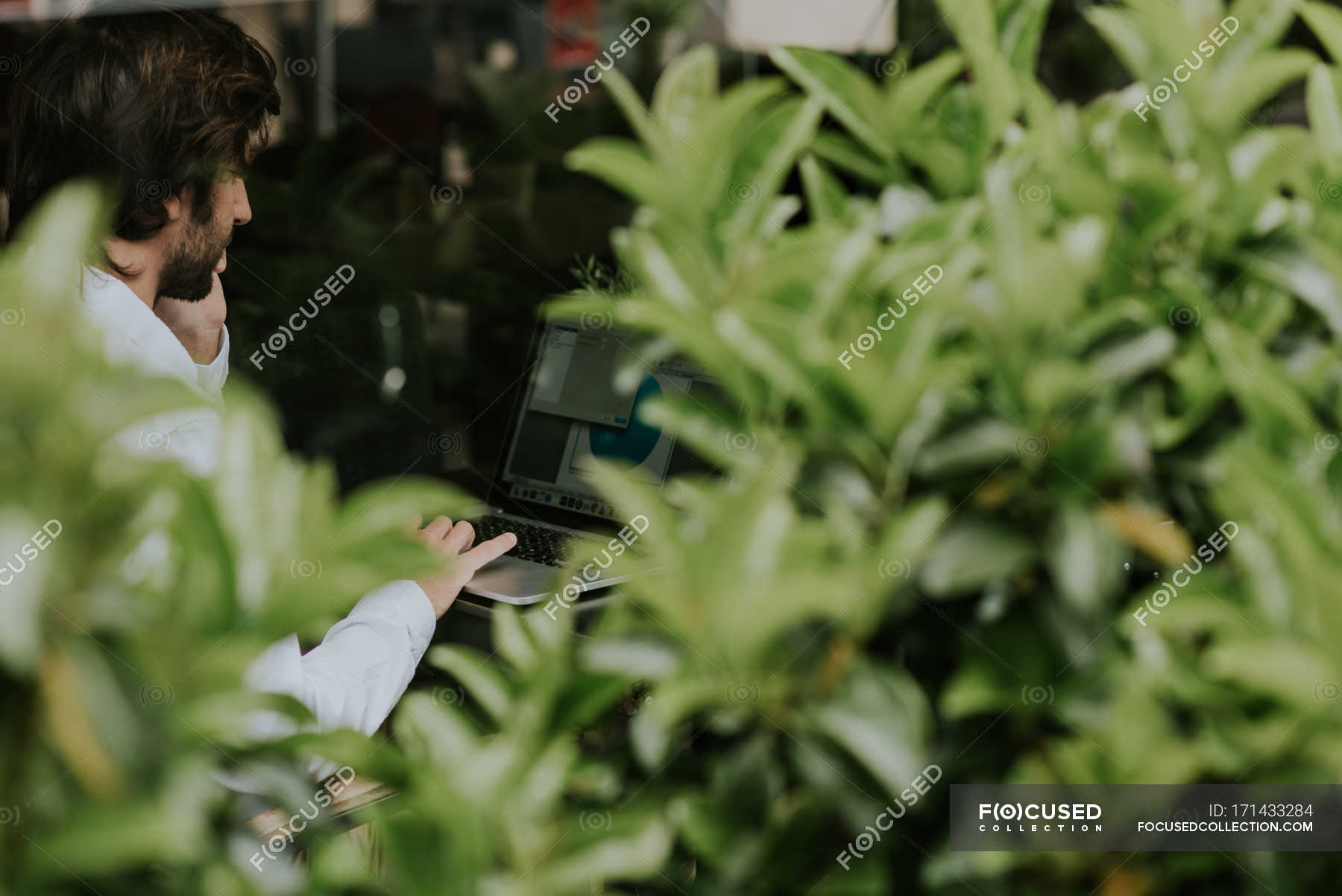 Side view of smiling businessman sitting at cafe terrace table with ... Side view of smiling businessman sitting at cafe terrace table with ...