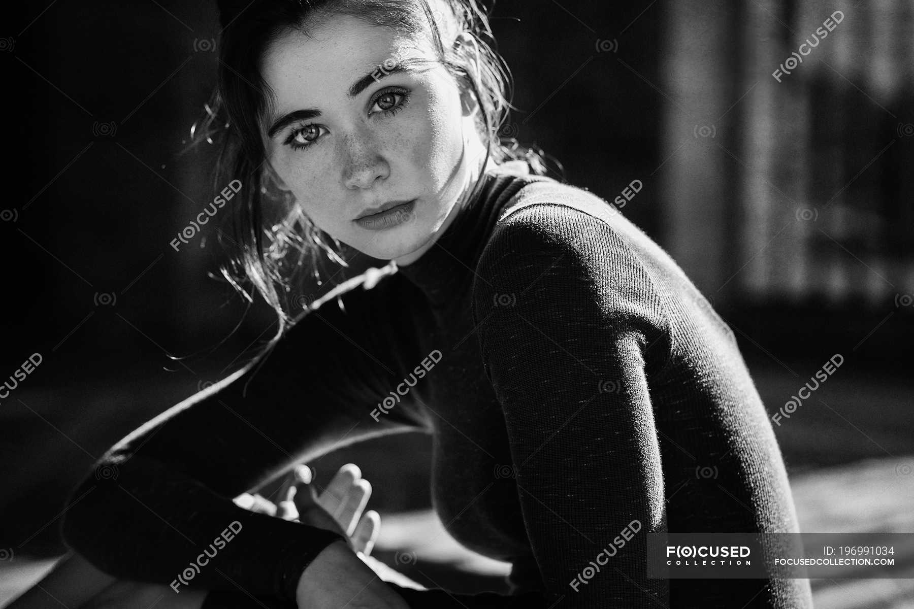 Sensual Girl Sitting On Floor In Sun Rays And Looking At Camera