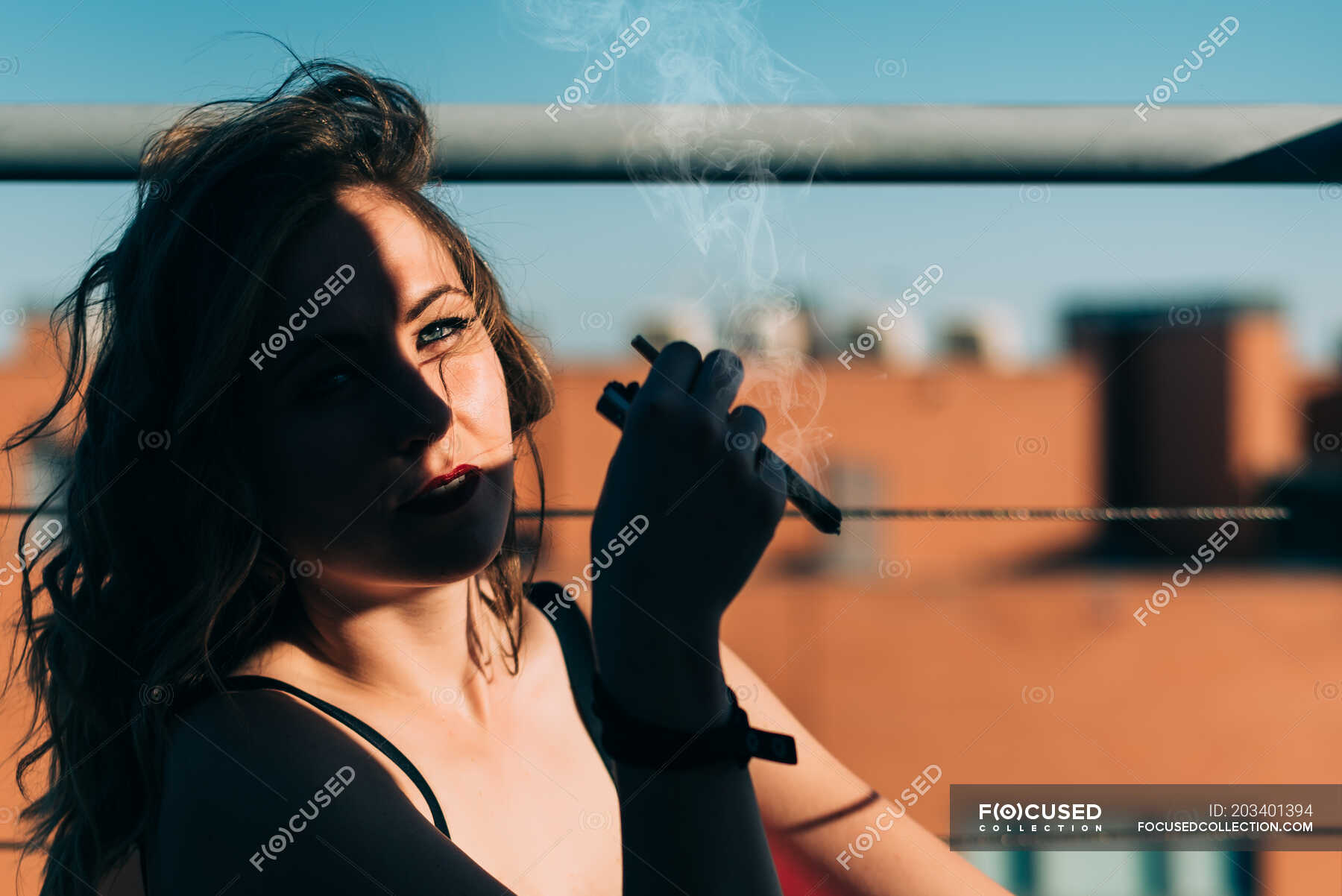 Young woman smoking a cannabis joint — attractive, horizontal - Stock Photo | #203401394