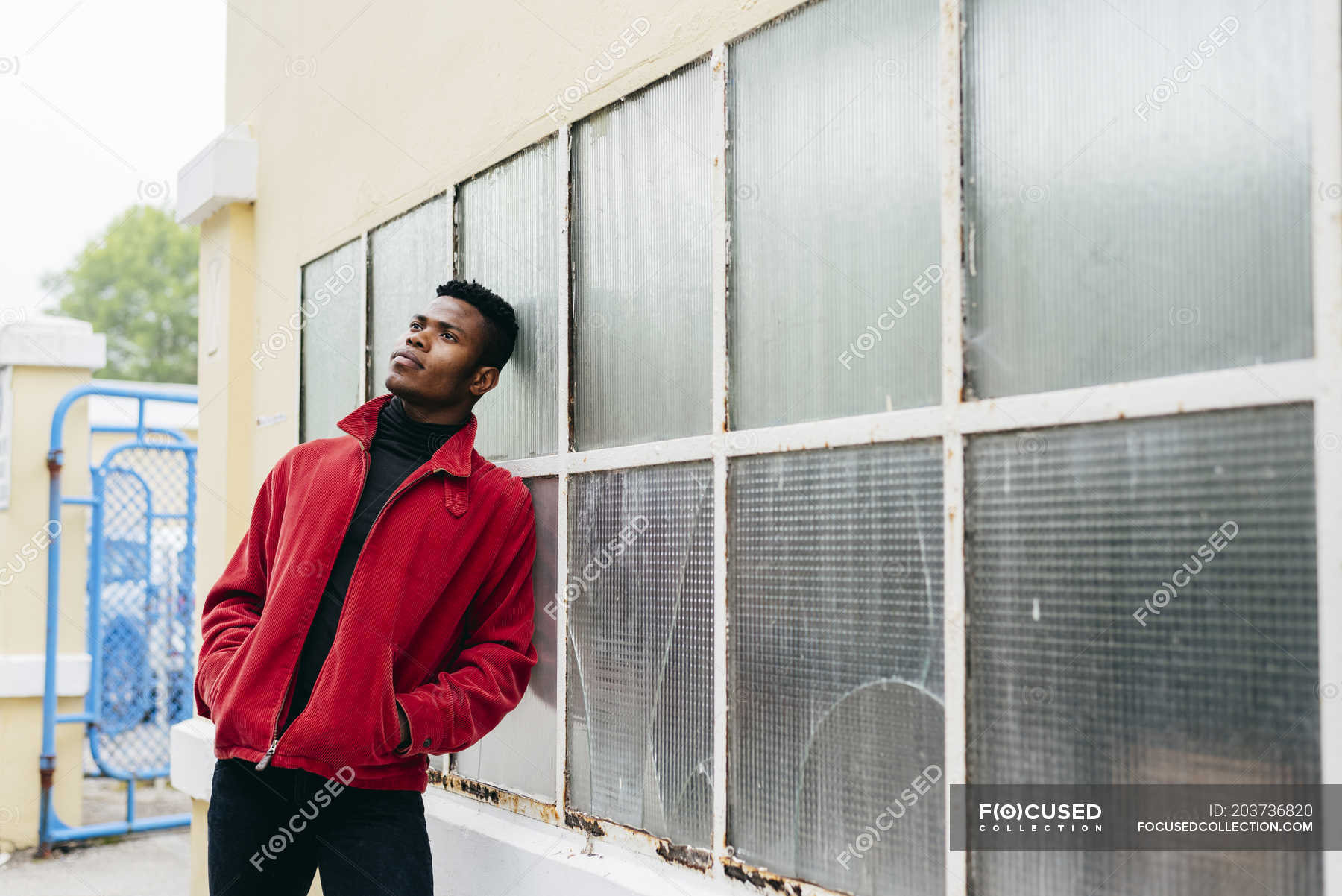 Black man leaning on glass wall — horizontal, thoughtful - Stock Photo ...