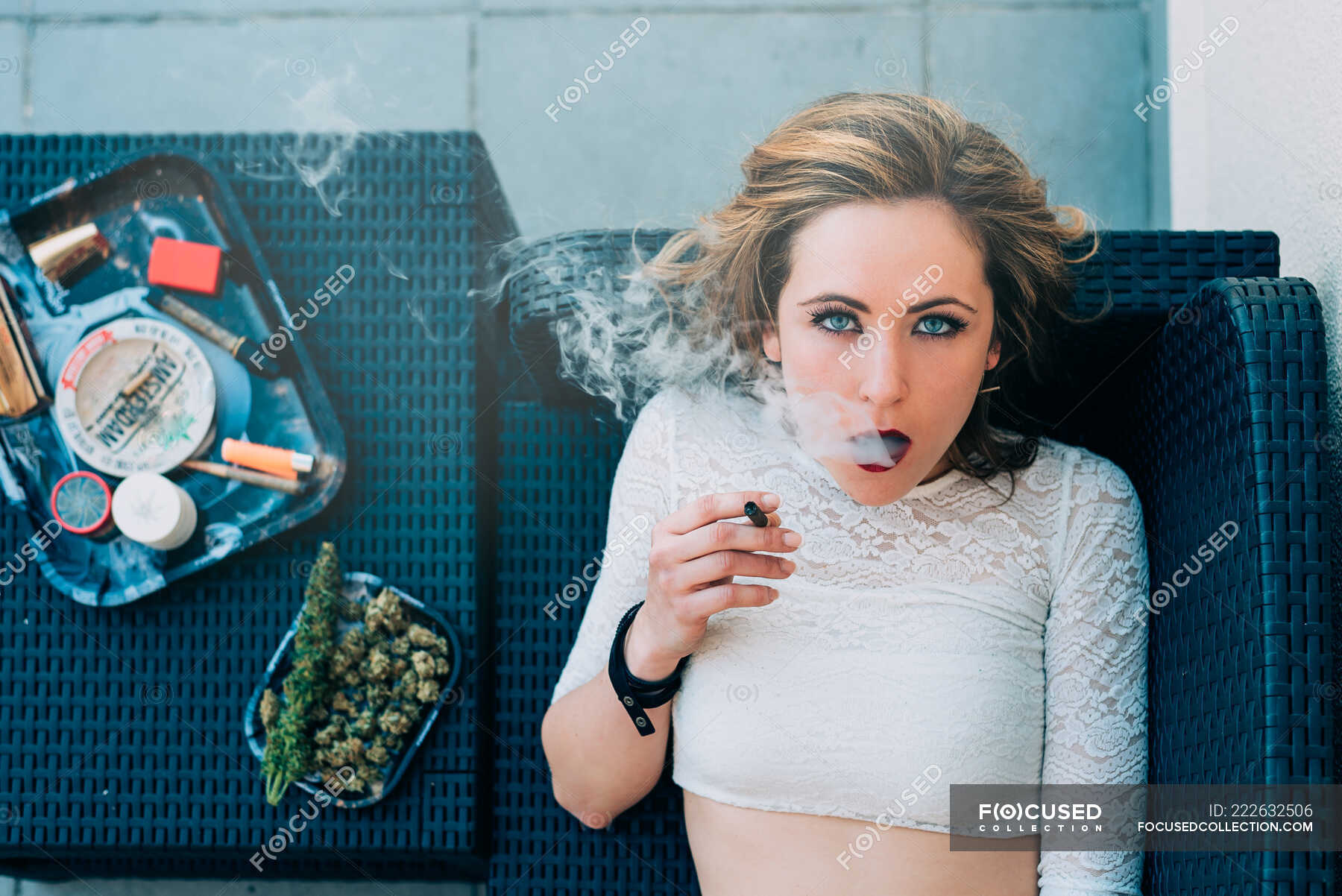 Young woman smoking a cannabis joint — blonde, indoors - Stock Photo | #222632506