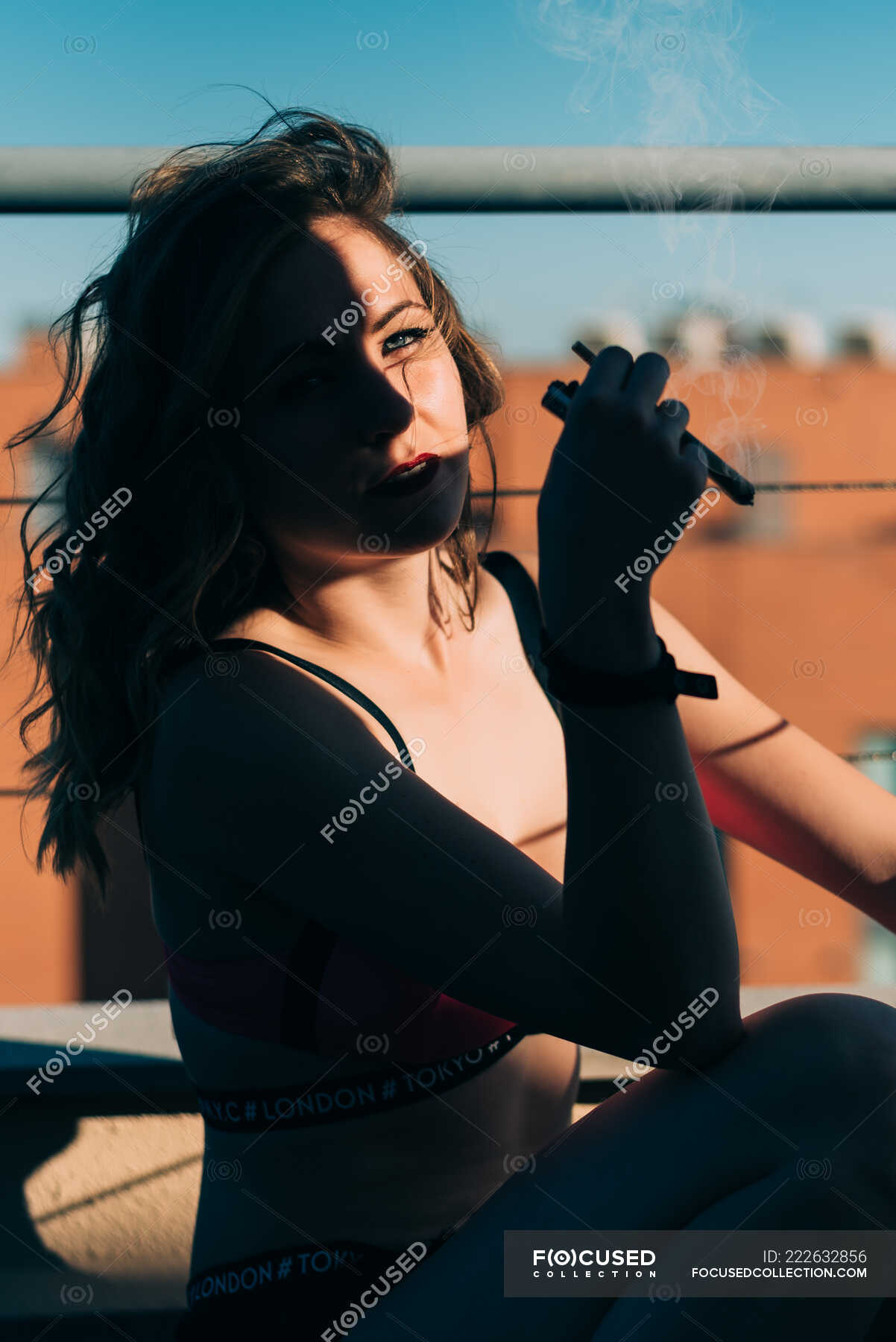Young woman smoking a cannabis joint — beautiful, smoke - Stock Photo | #222632856