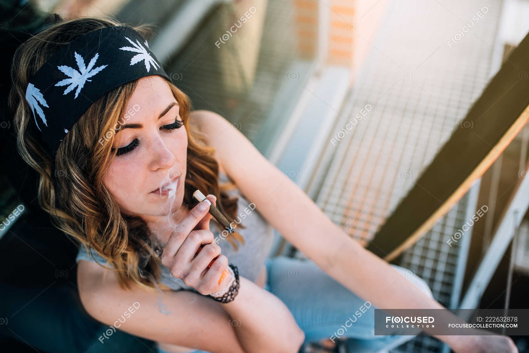 Young woman smoking a cannabis joint — legalize, smoke - Stock Photo | #222632878
