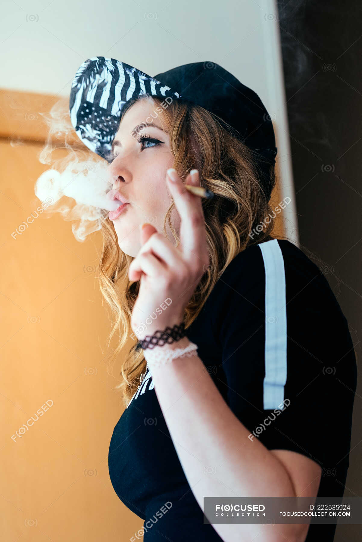 Young woman smoking a cannabis joint — adult, caucasian - Stock Photo | #222635924
