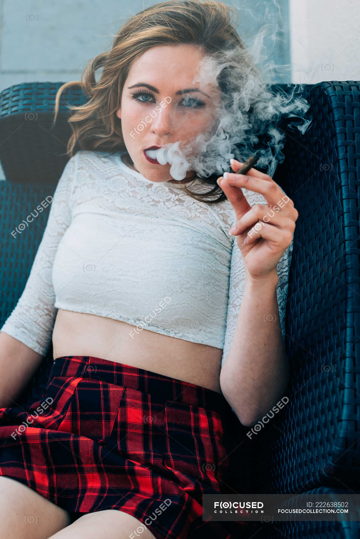 Young woman smoking a cannabis joint — vertical, blonde - Stock Photo | #222638502