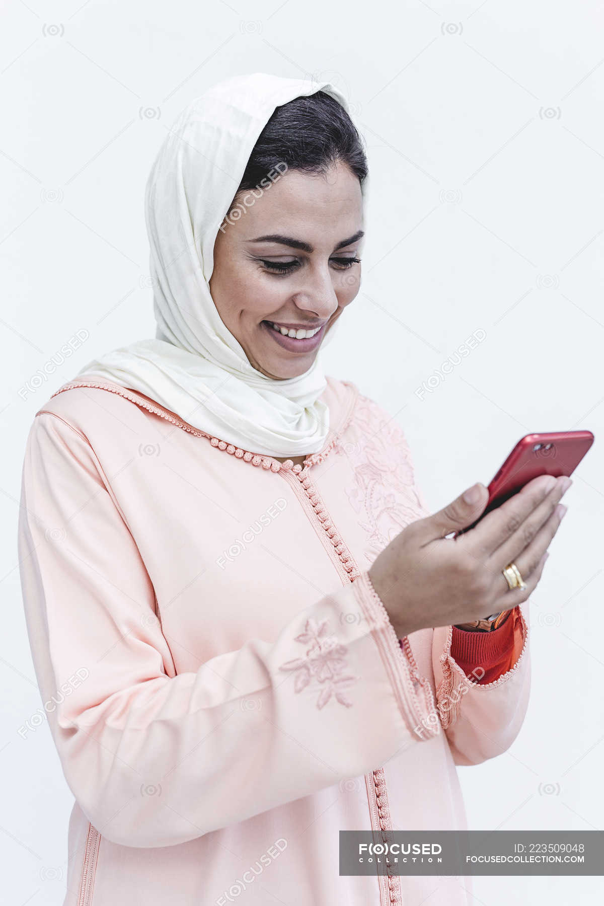 Smiling Moroccan woman with hijab and typical Arabic dress using mobile ... Smiling Moroccan woman with hijab and typical Arabic dress using mobile ...