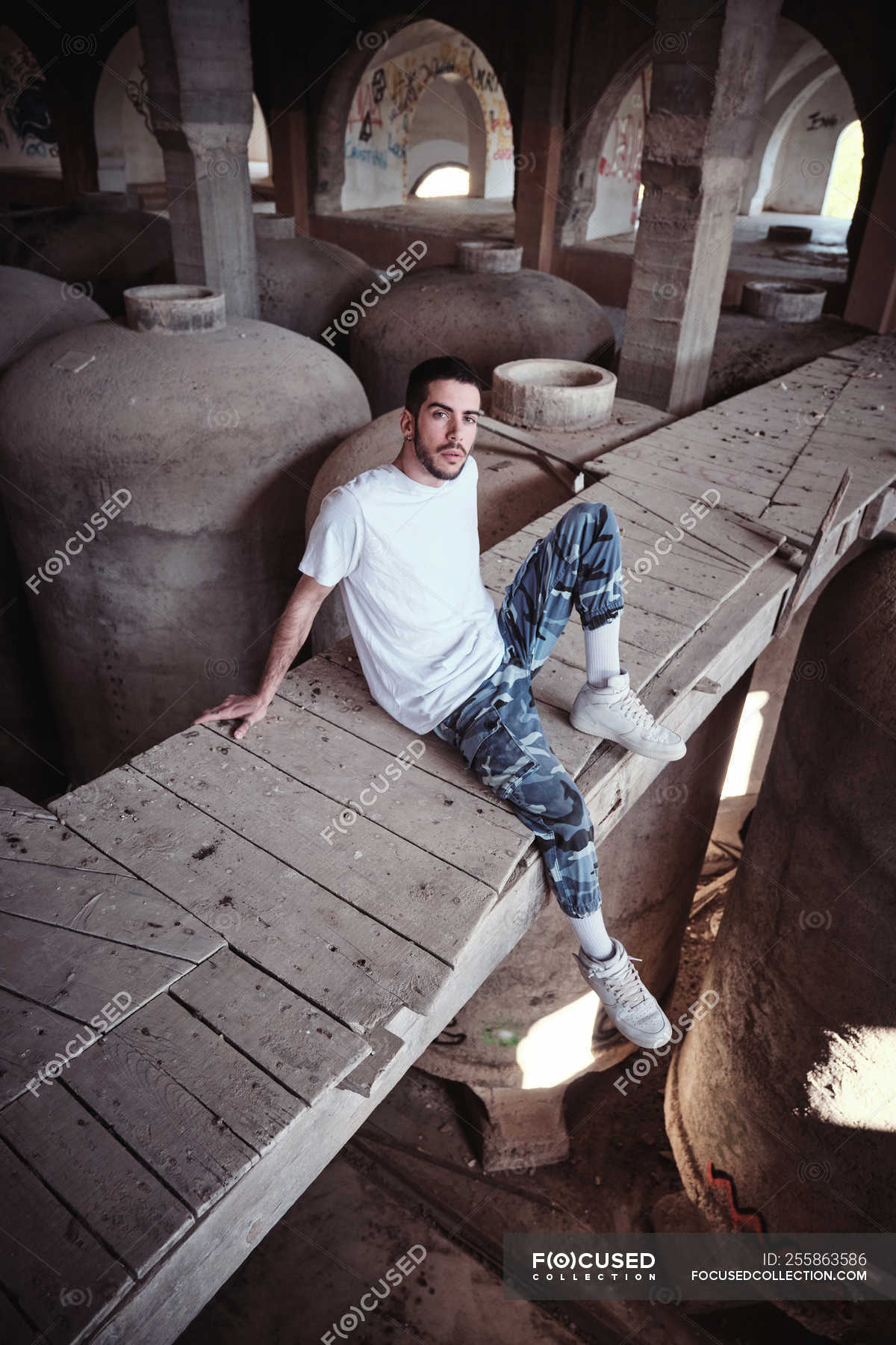 Man sitting on bridge inside old building — style, indoors - Stock ...