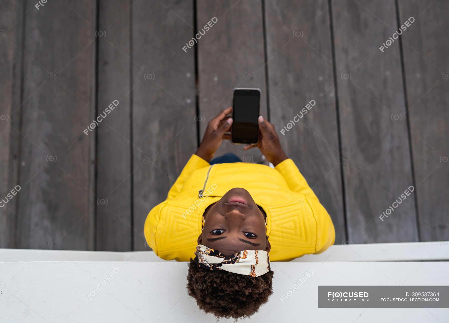 Top view of modern African American woman leaning on wall of modern ...