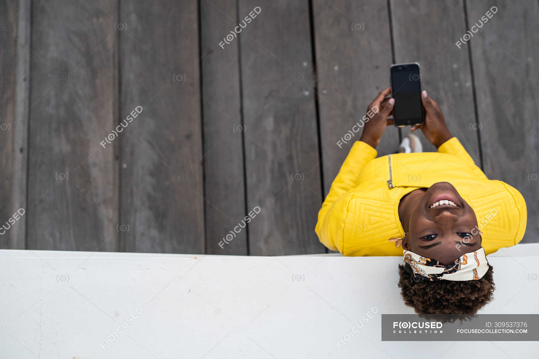 Top view of modern African American woman leaning on wall of modern ...