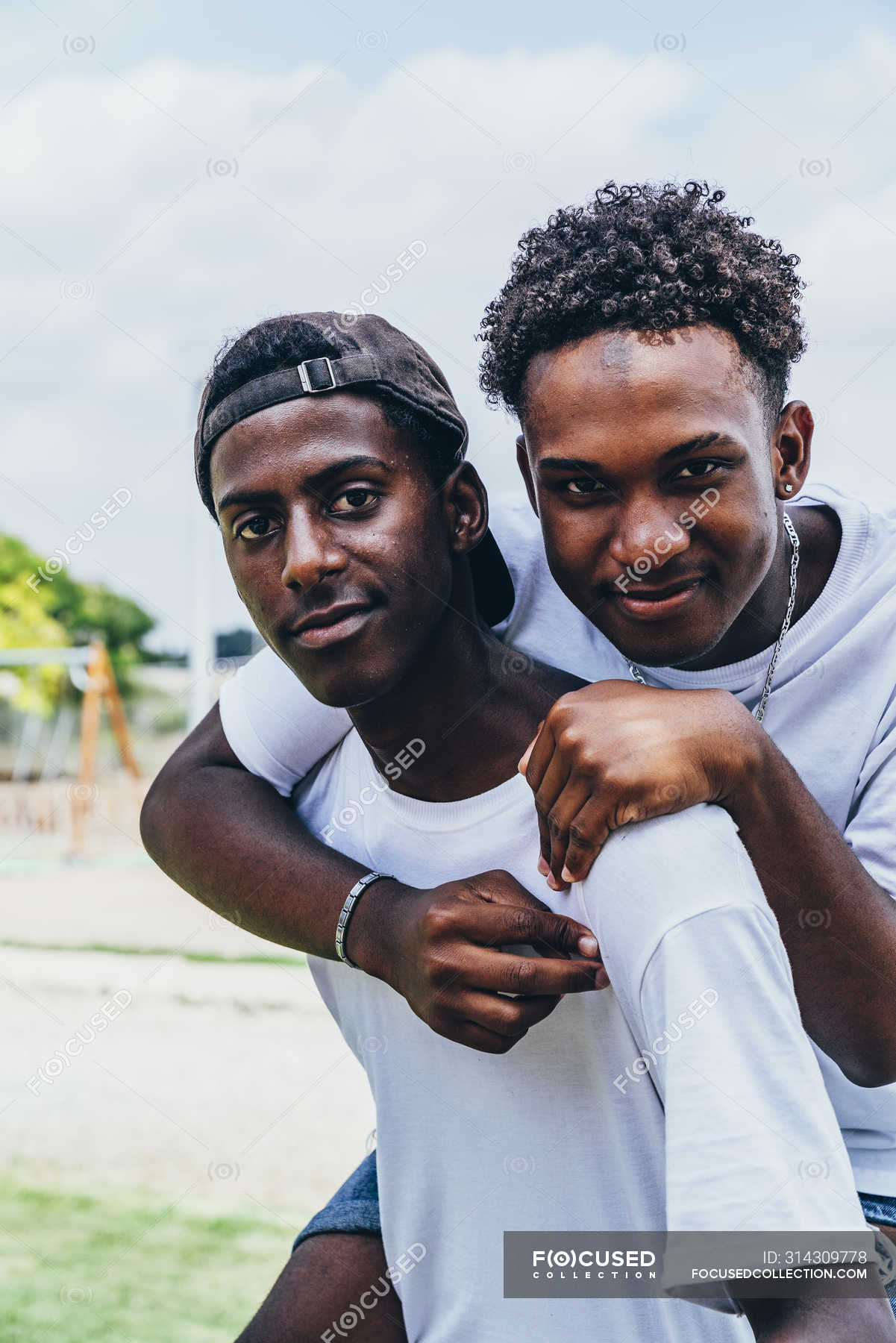 Cheerful Hugging African American Young Men Looking At Camera And