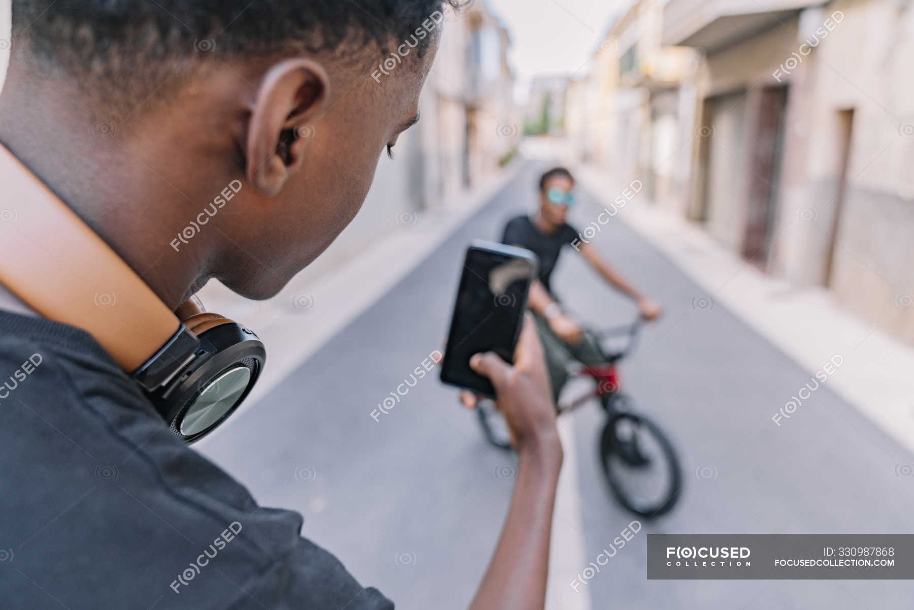 From above crop focused young African American guy taking picture on ... From above crop focused young African American guy taking picture on ...