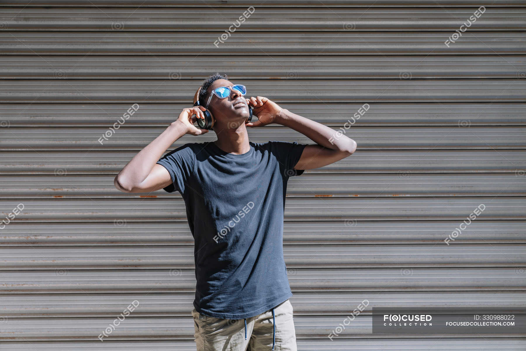 Stylish modern African American man in sunglasses and headphones ... Stylish modern African American man in sunglasses and headphones ...