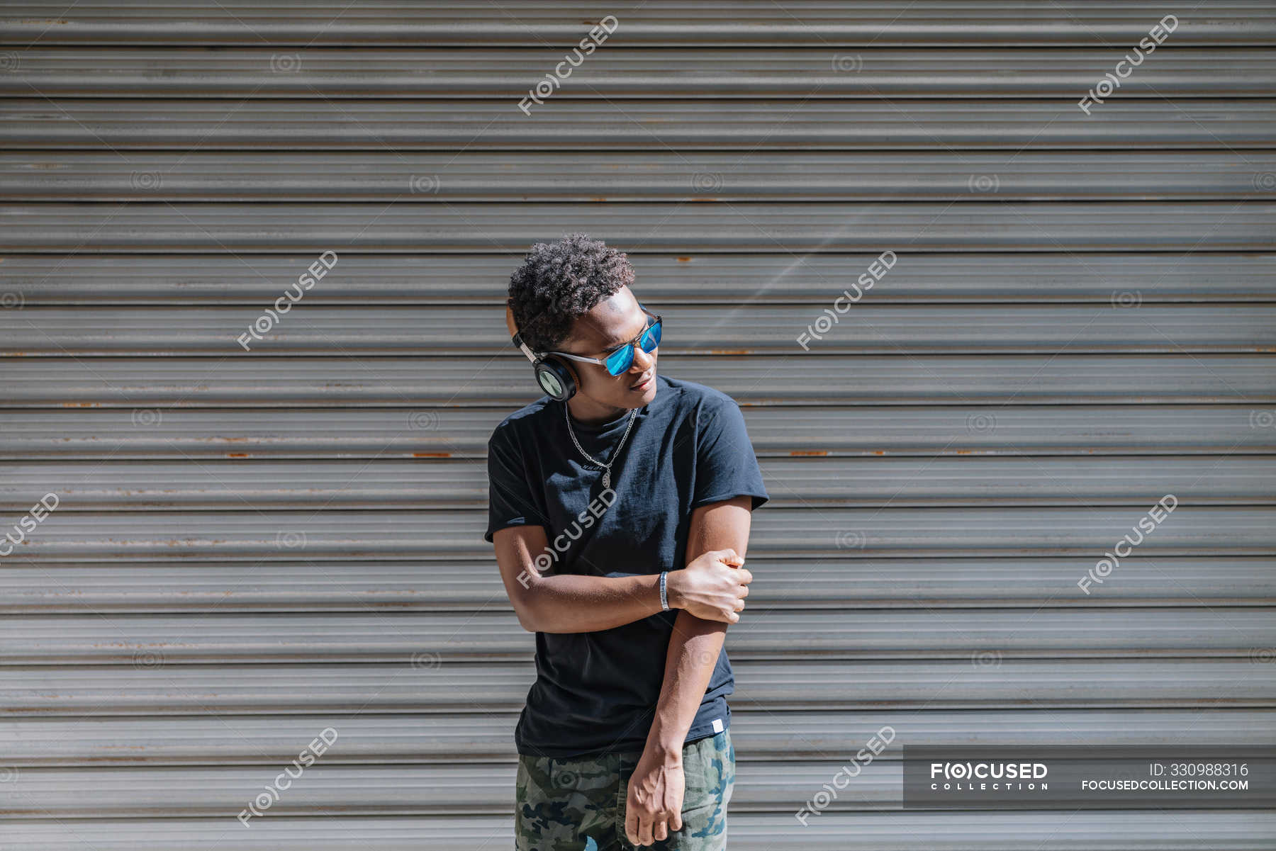 Stylish modern African American man in sunglasses and headphones ... Stylish modern African American man in sunglasses and headphones ...