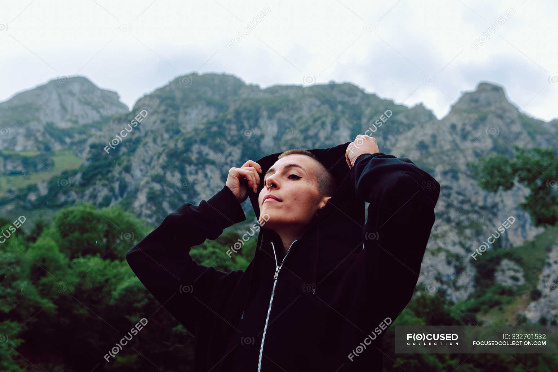Woman With Short Hairstyle And Piercing In Casual Clothing Looking Up