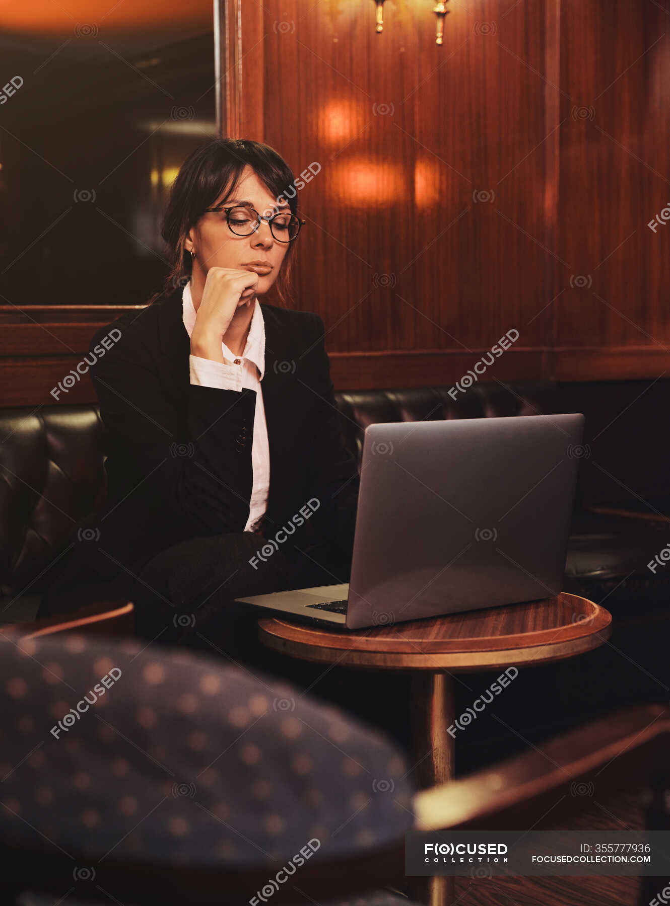 Smart business woman in glasses typing on laptop comfortably sitting in ...