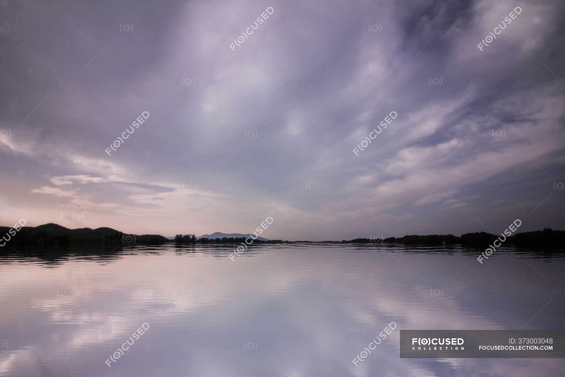 Cloudy sky reflecting in tranquil lake water — serene, landscape ...