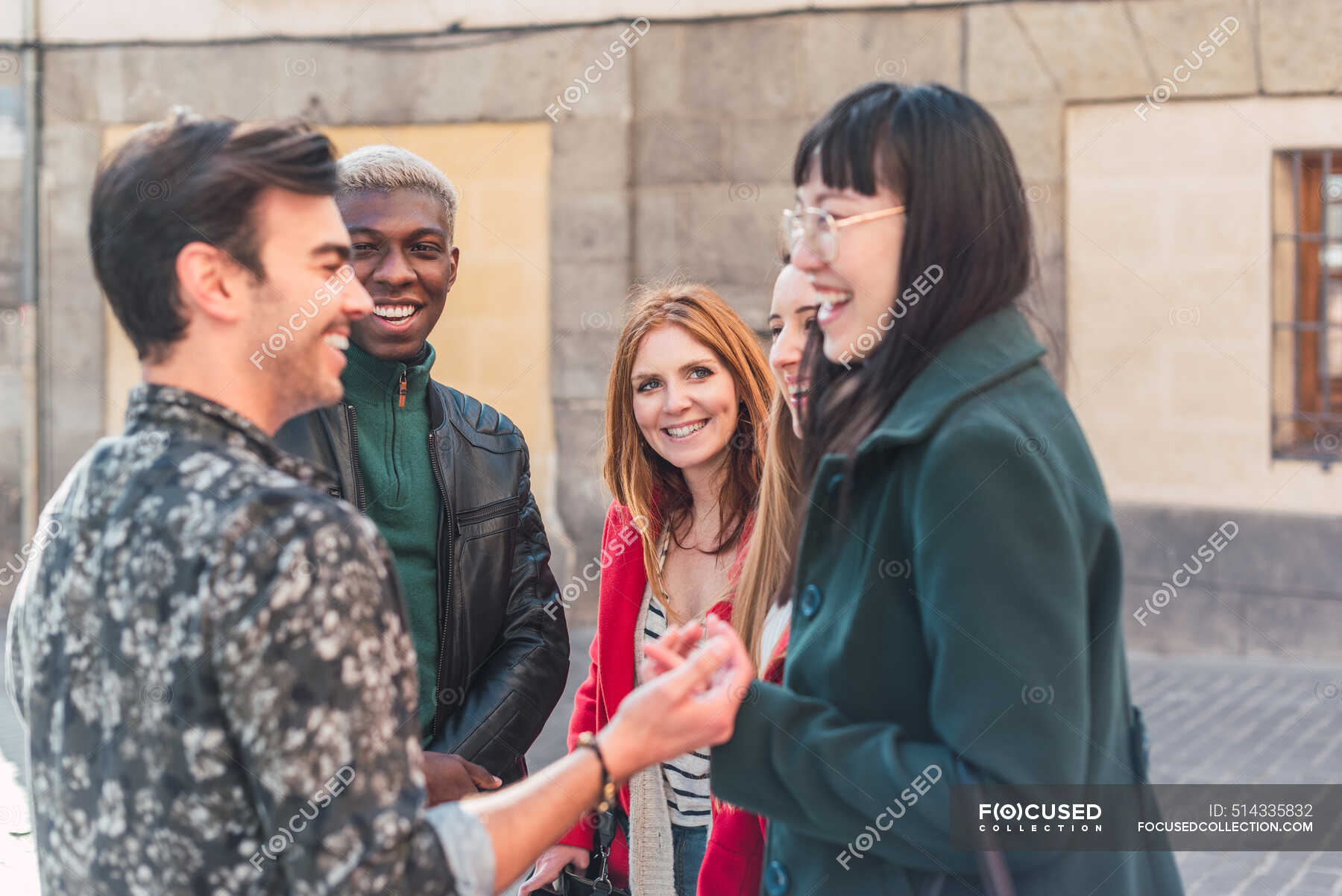 Group of cheerful diverse friends standing in city street and enjoying ... Group of cheerful diverse friends standing in city street and enjoying ...