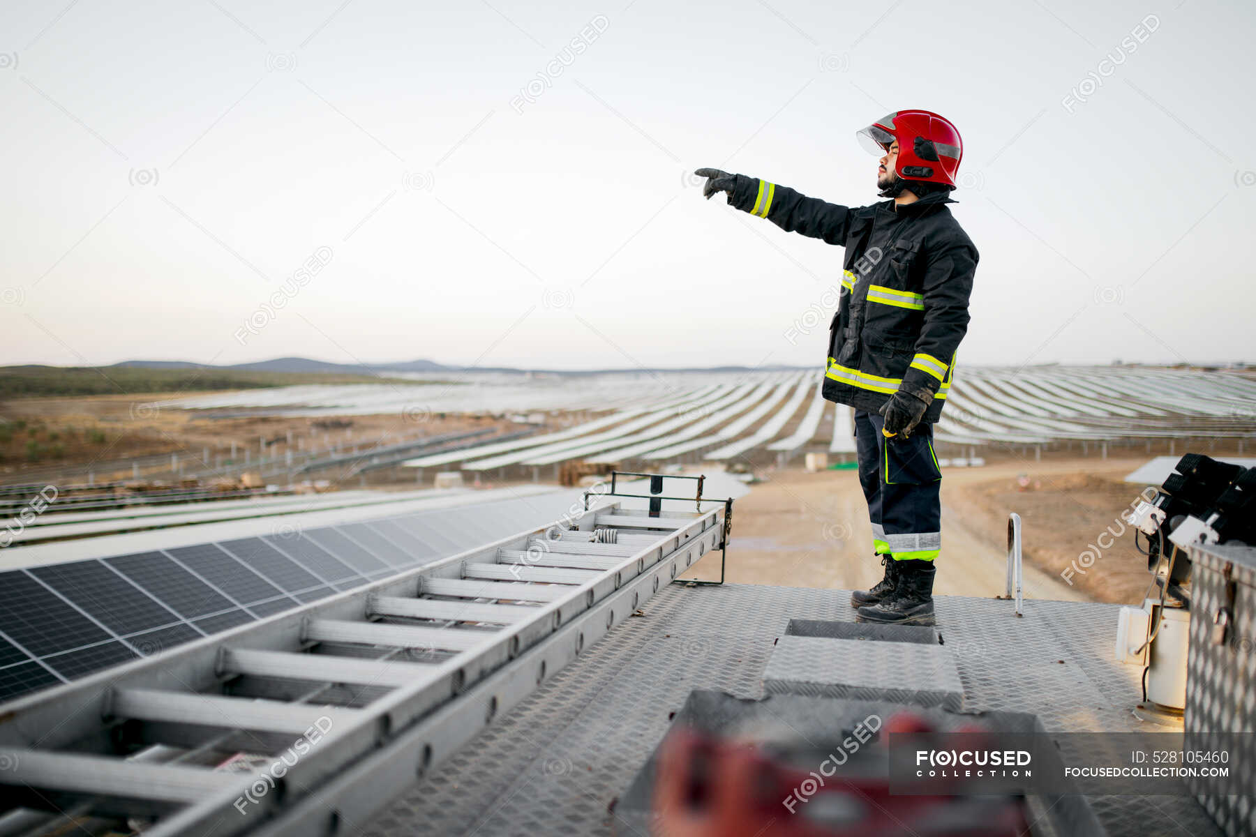 Full body side view of male firefighter wearing uniform and gloves ...